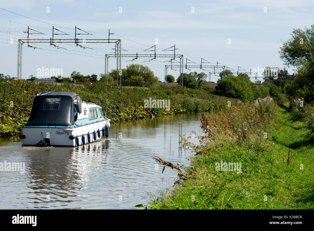 Cabin cruiser on the Oxford Canal alongside the West Coast Main Line ...