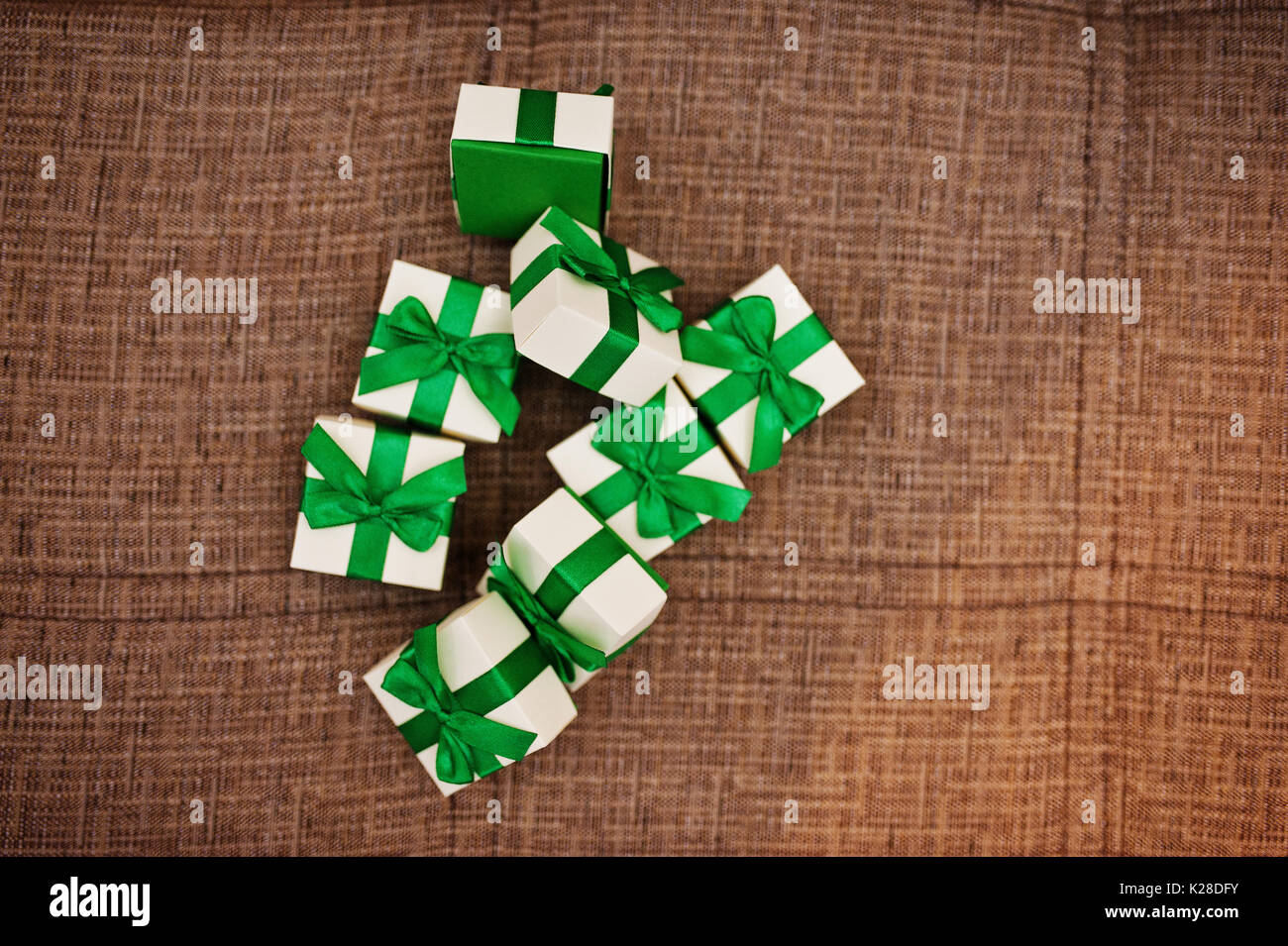 Small boxes tied with green ribbon on the textured surface Stock Photo ...