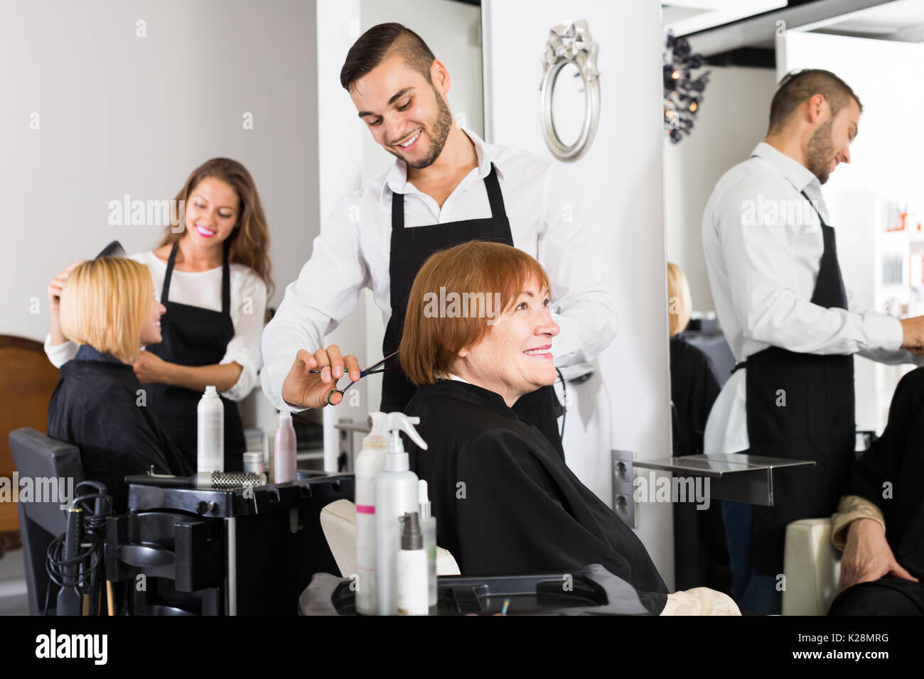 smiling russian barber makes the cut for mature woman Stock Photo - Alamy