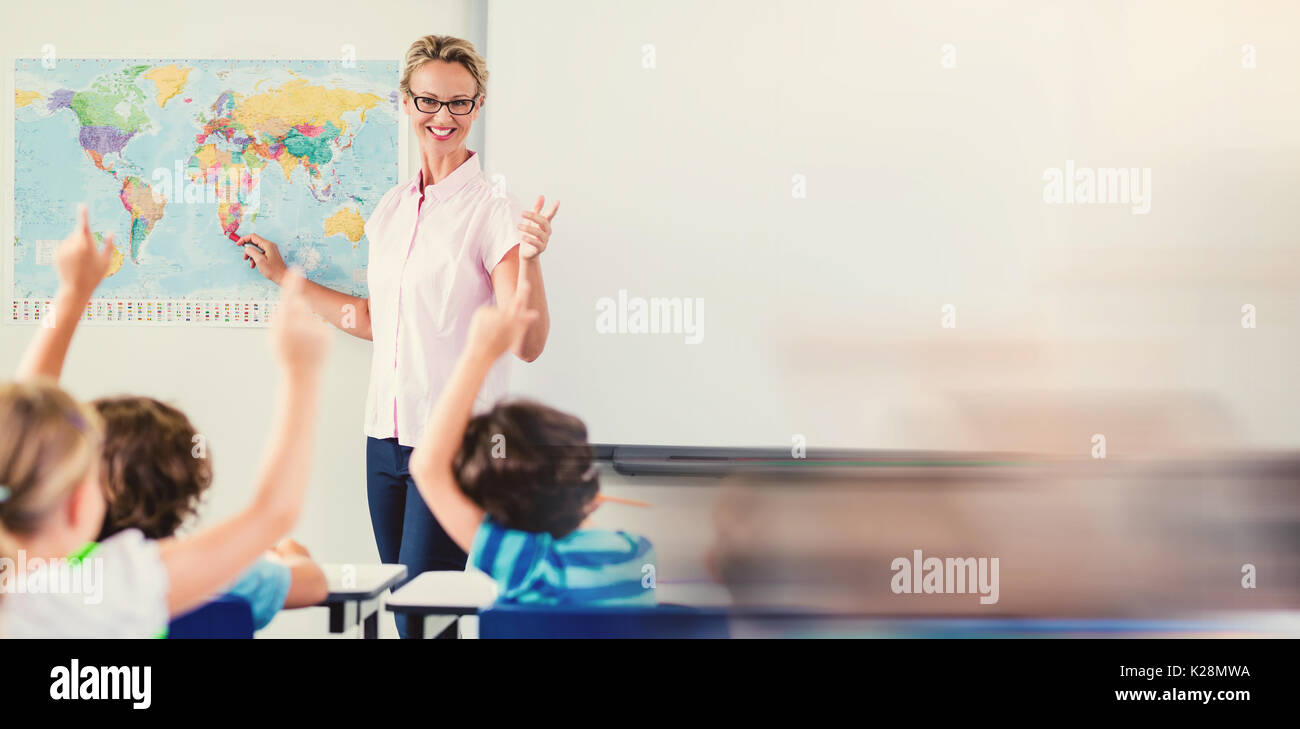 Teacher teaching kids in classroom Stock Photo - Alamy