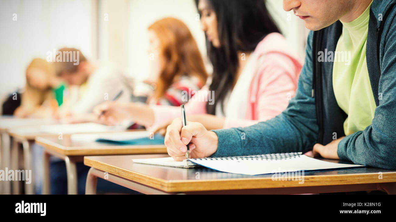 Young students writing notes in classroom Stock Photo - Alamy