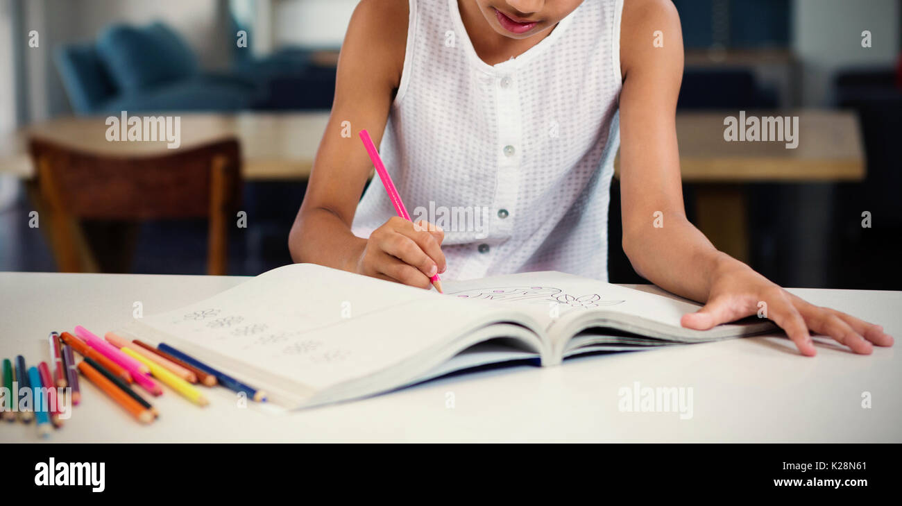 Concentrated girl drawing in book Stock Photo - Alamy