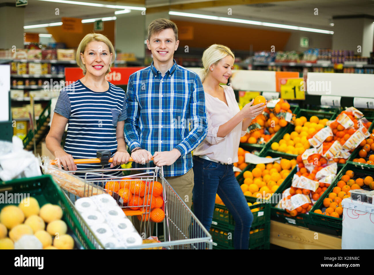 Happy customers choosing fresh frusits in food store Stock Photo - Alamy