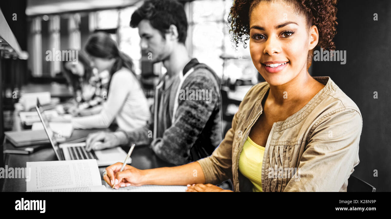 Student looking at camera while studying with classmates Stock Photo ...