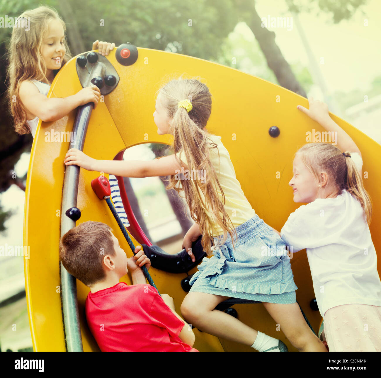 Smiling cheerful kids in school age climbing together on playground's ...