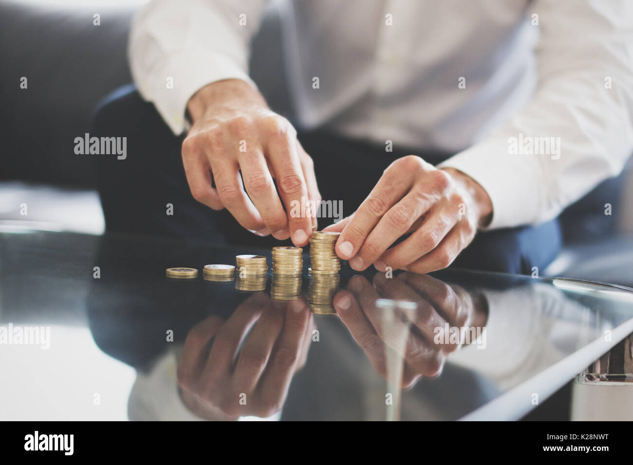 Businessman hands building money columns on glass desk, investment ...