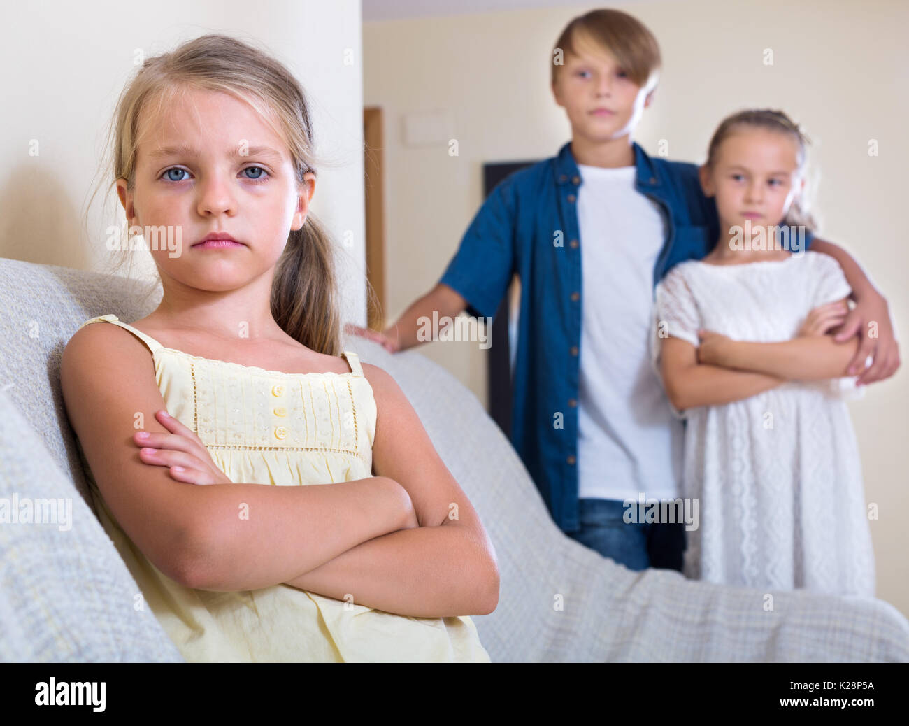 Envy child sitting aside of boy and girl in flat Stock Photo - Alamy
