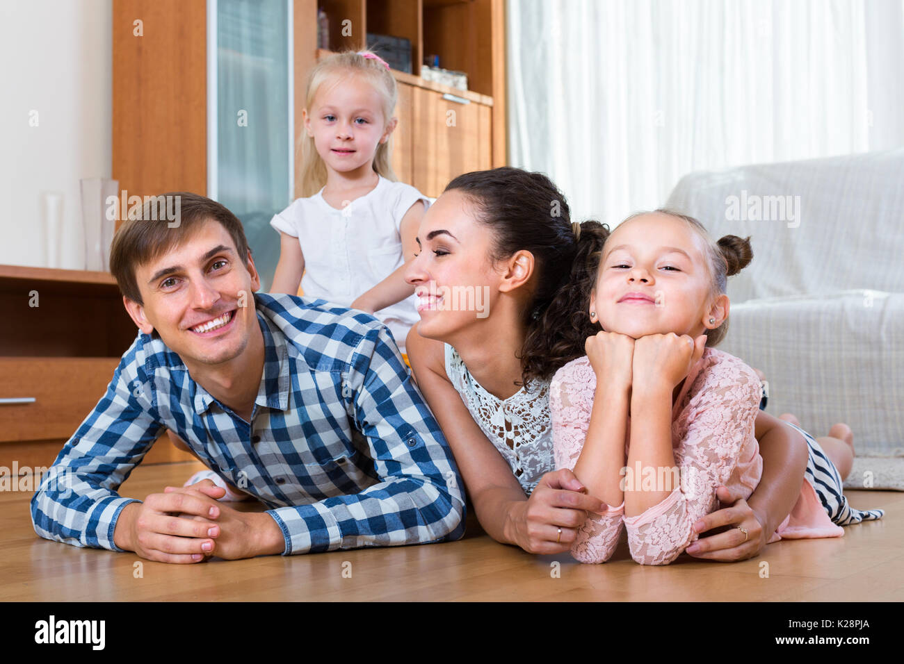 Family values: portrait of happy european parents with little girls ...