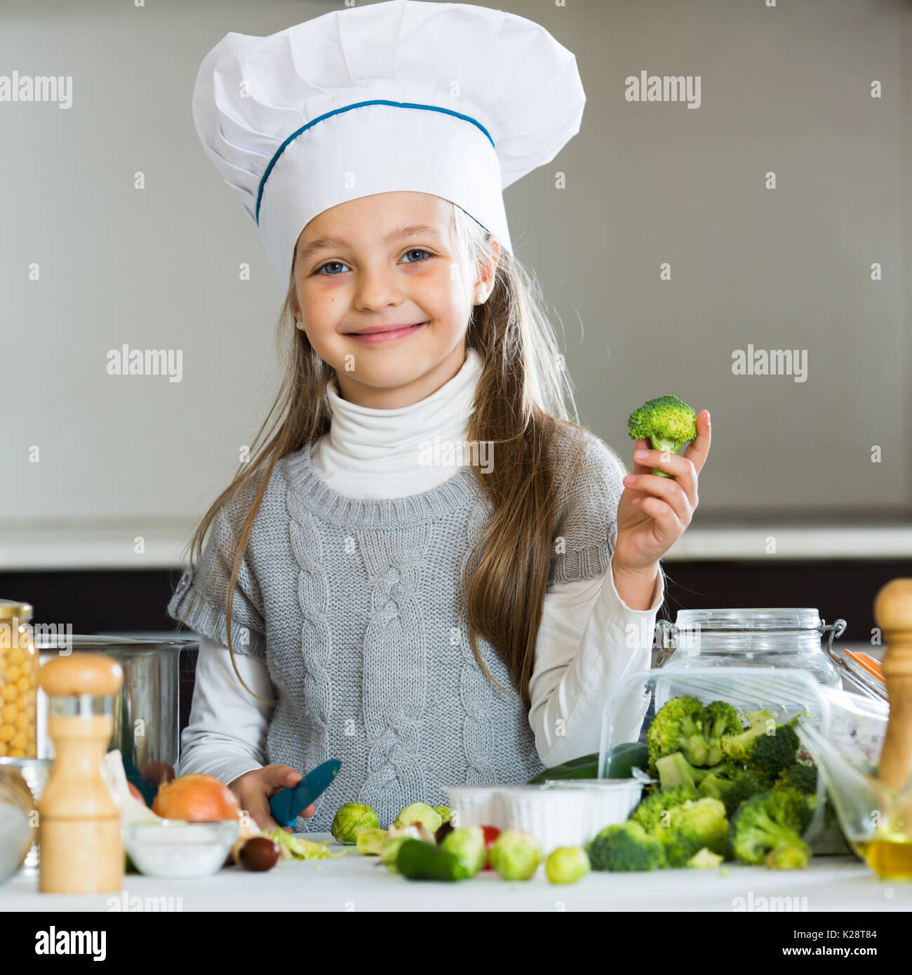Portrait of cute little girl in cook cap cooking veggies Stock Photo ...