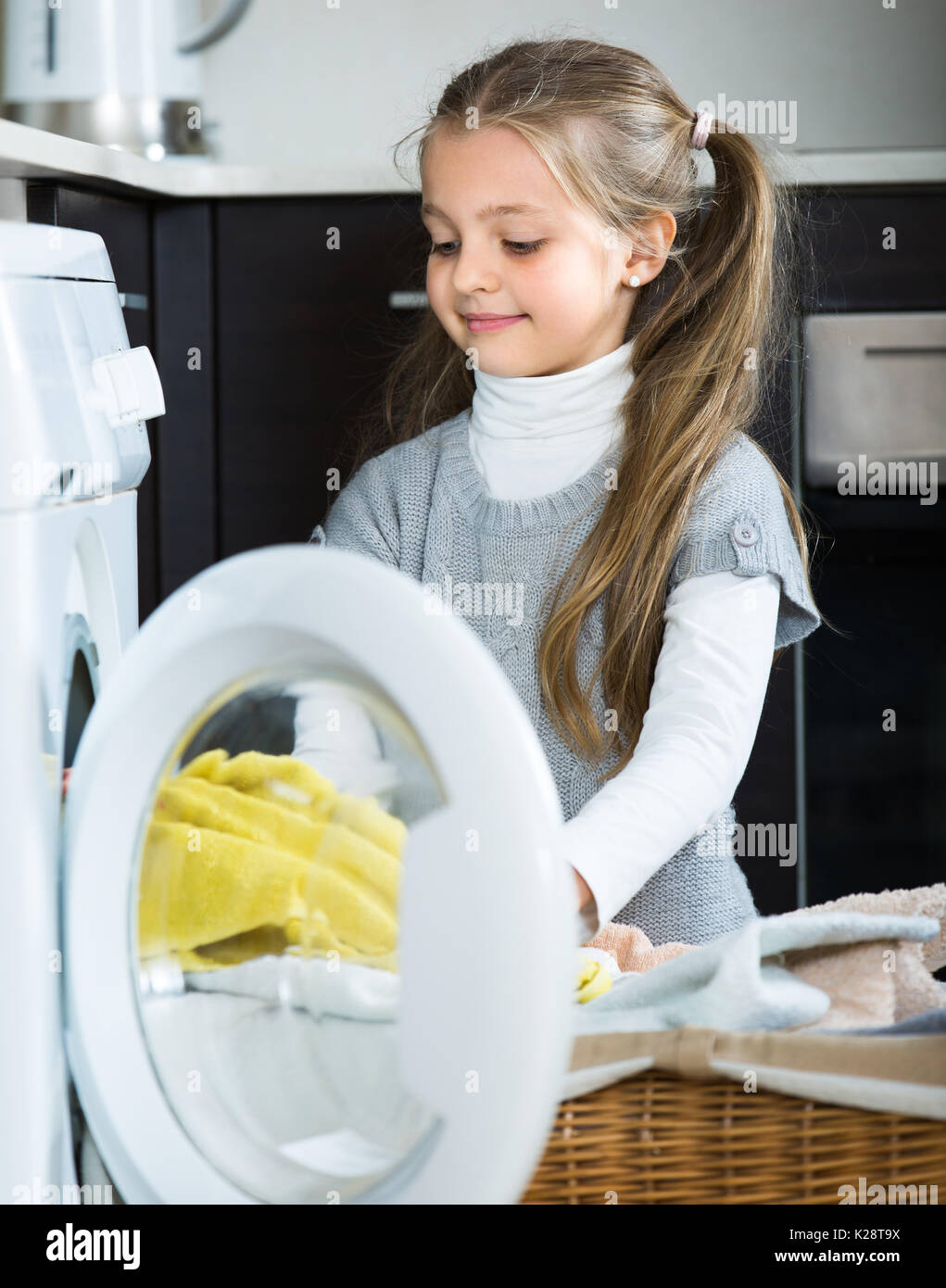 Happy little girl doing laundry in home interior Stock Photo - Alamy