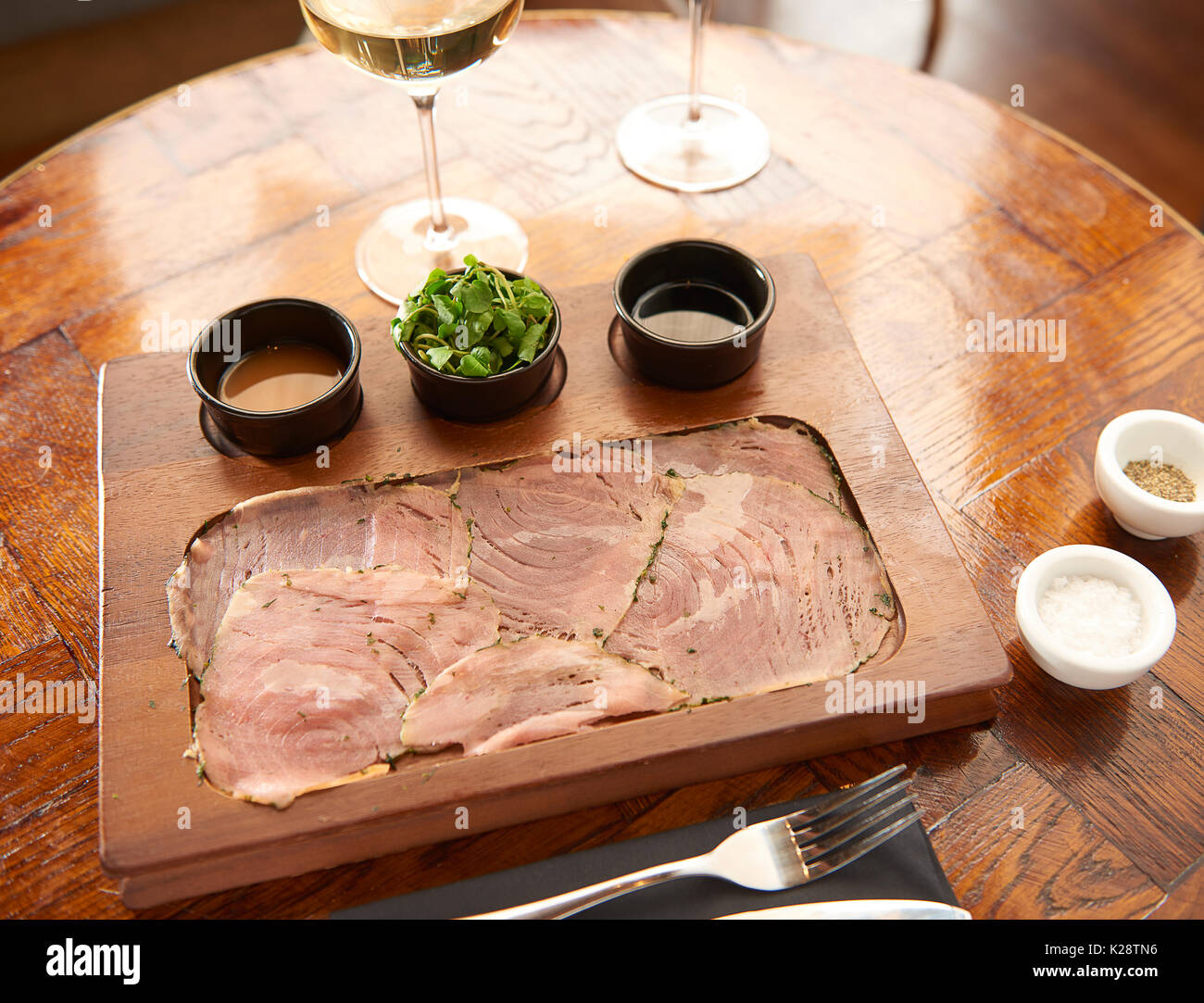 thin sliced tuna starters and wine Stock Photo - Alamy