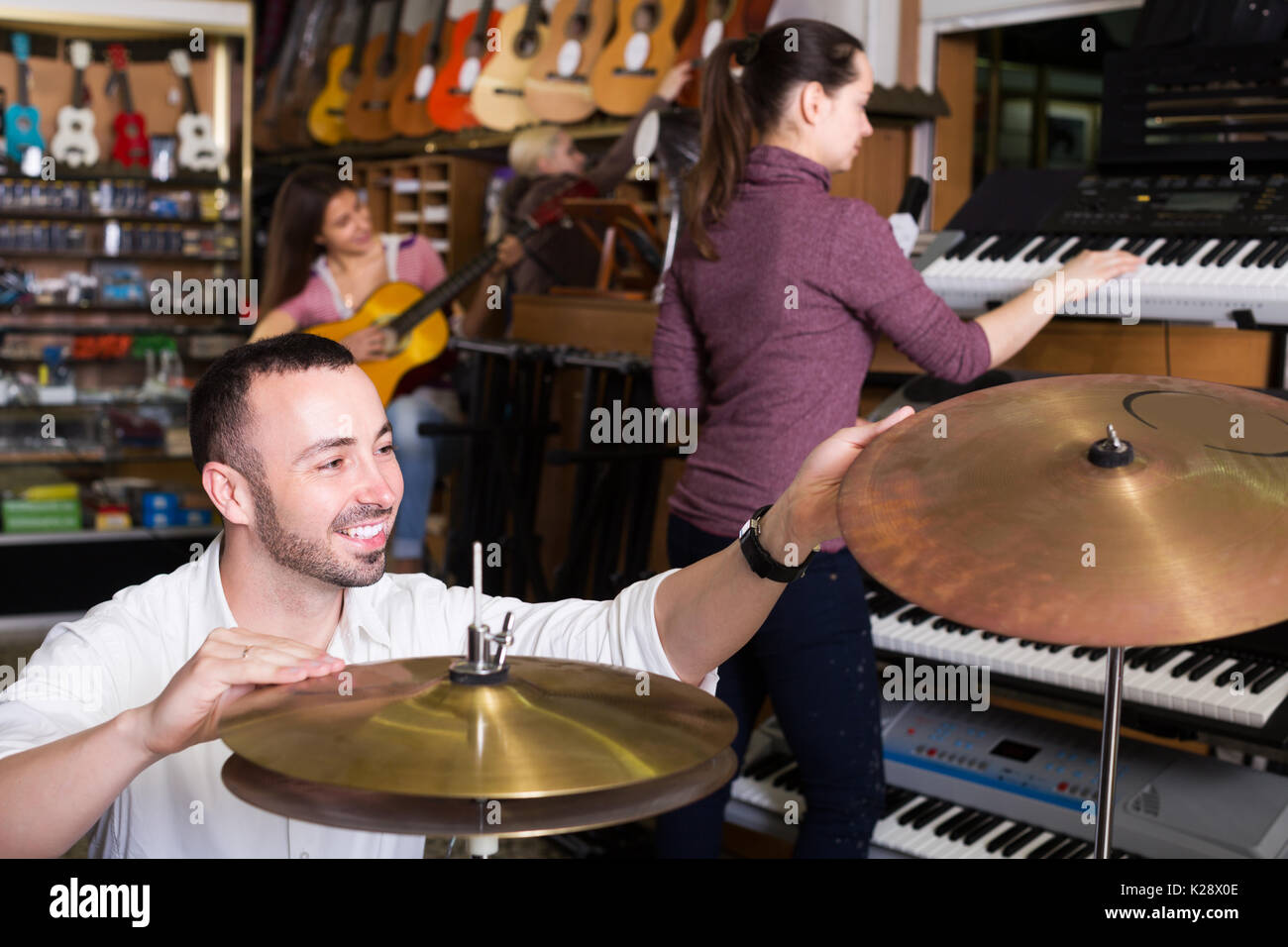 Different young people looking at professional musical instruments in ...