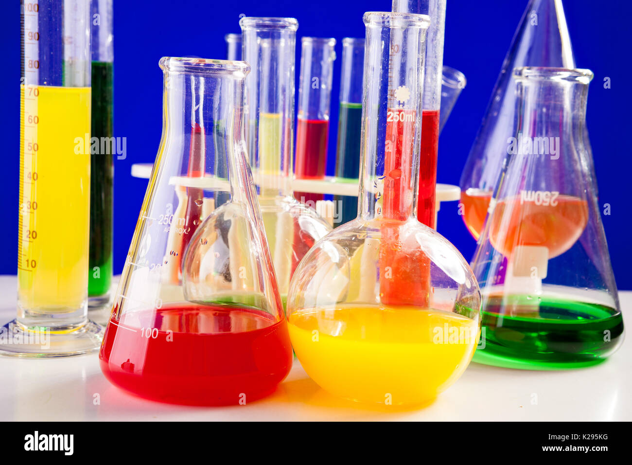Chemistry lab set with colored liquids on a table over blue back Stock ...