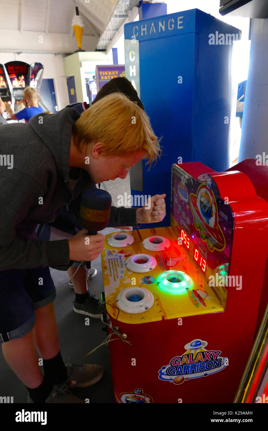 boy playing on machine in an amusement arcade Stock Photo - Alamy