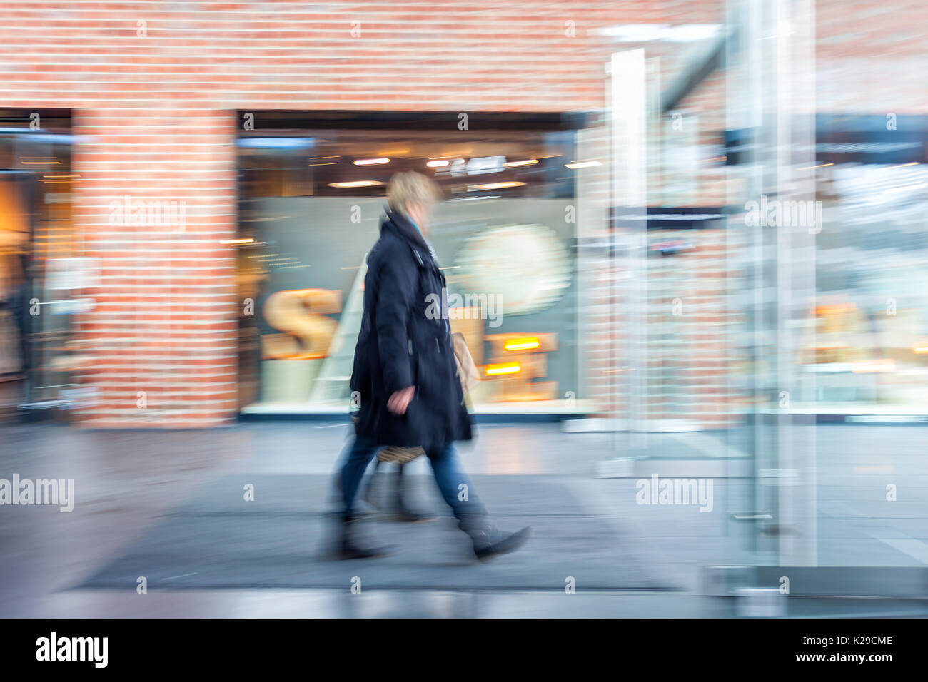 A shopper walking in front of shop window Stock Photo - Alamy