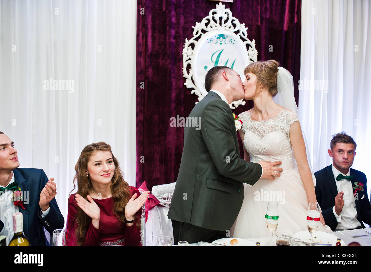 Wedding couple kissing at the table in restaurant Stock Photo - Alamy