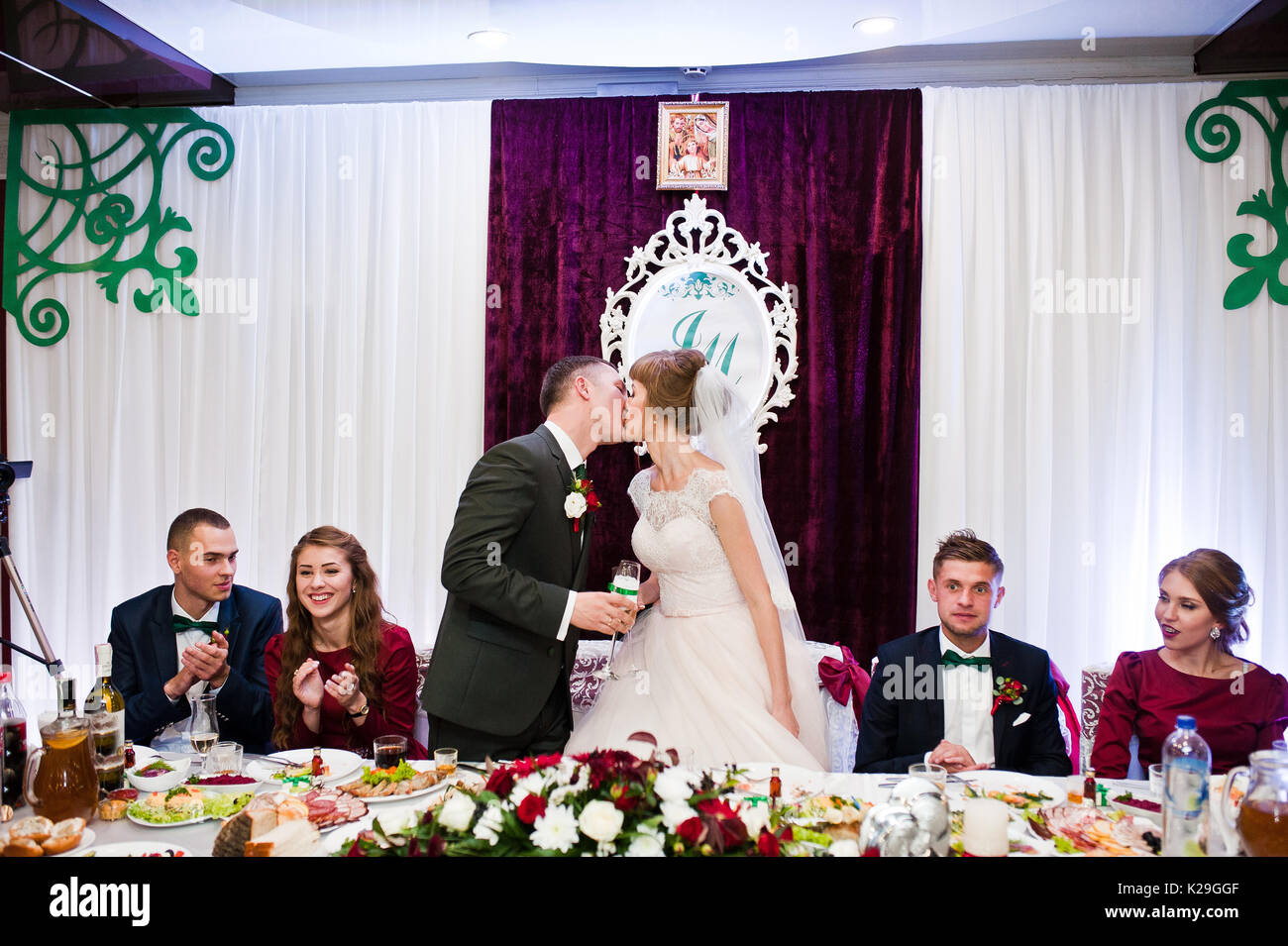 Wedding couple kissing at the table in restaurant Stock Photo - Alamy