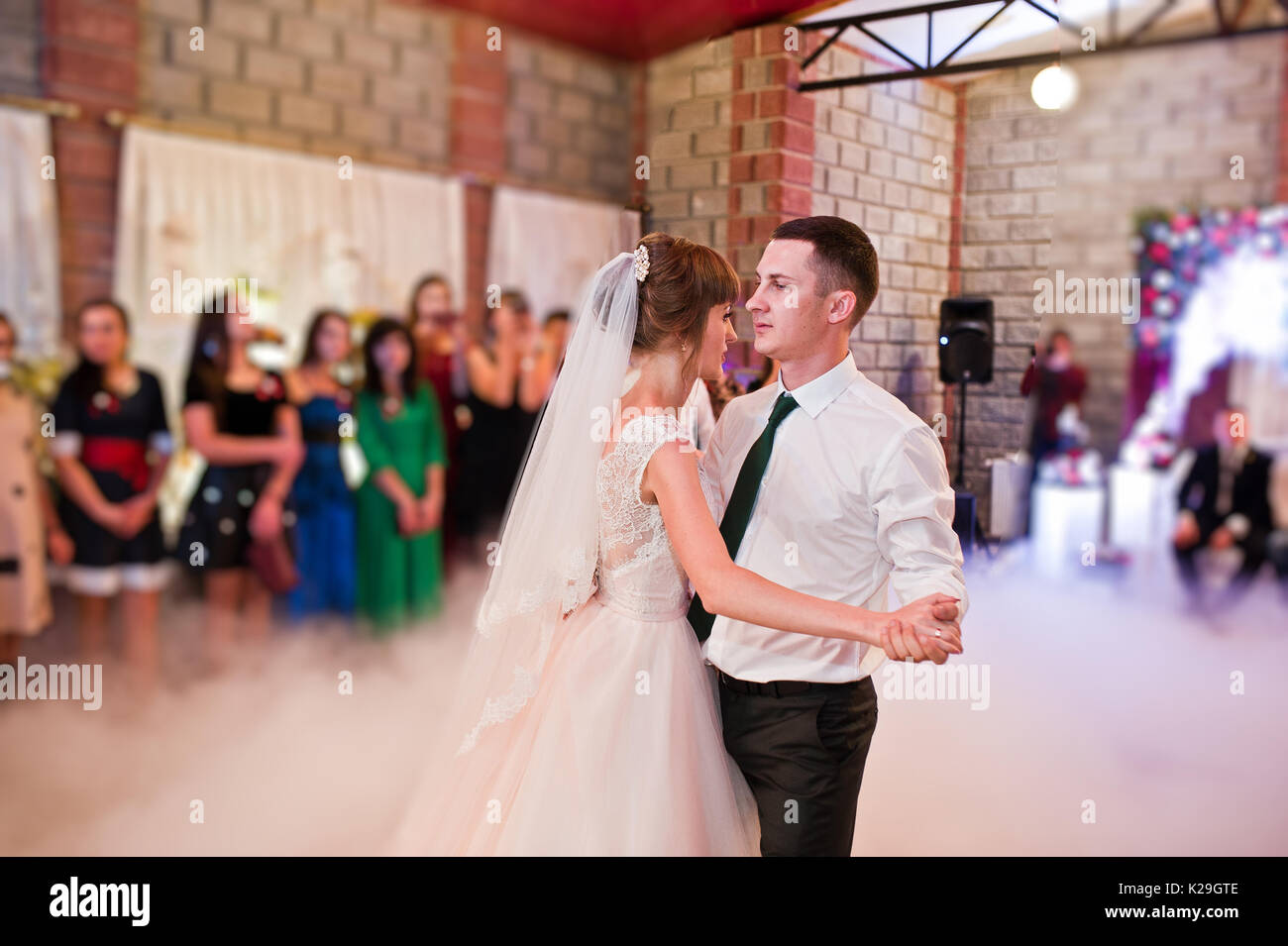 Wedding couple dancing their first wedding dance with heavy smoke and ...