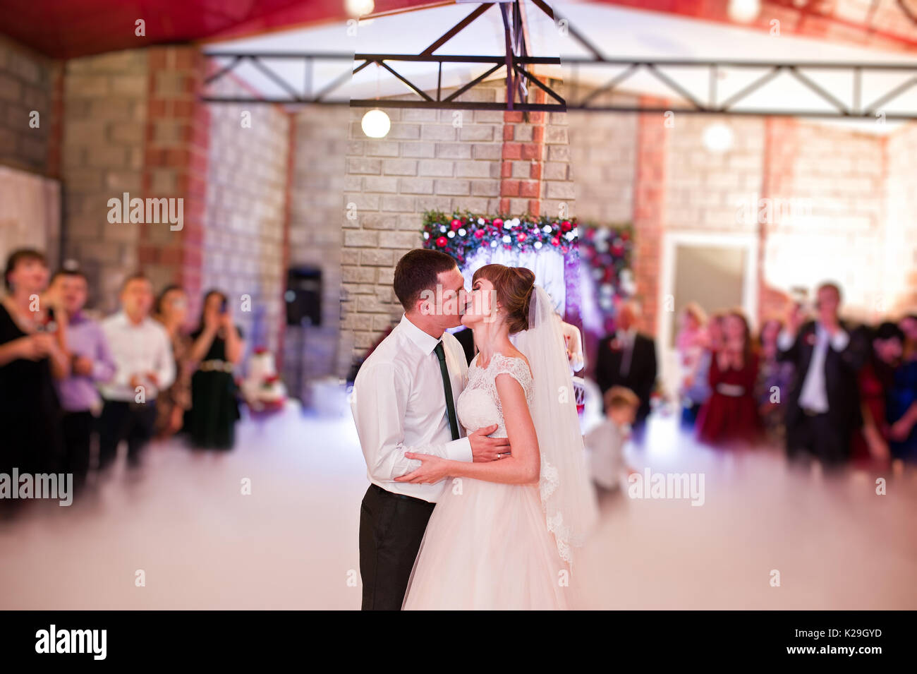 Wedding couple dancing their first wedding dance with heavy smoke and different lights in the ...