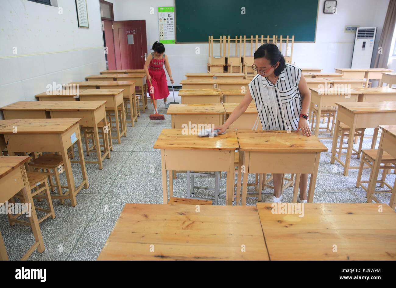 Chongqing, China. 29th Aug, 2017. Teachers clean a classroom at ...