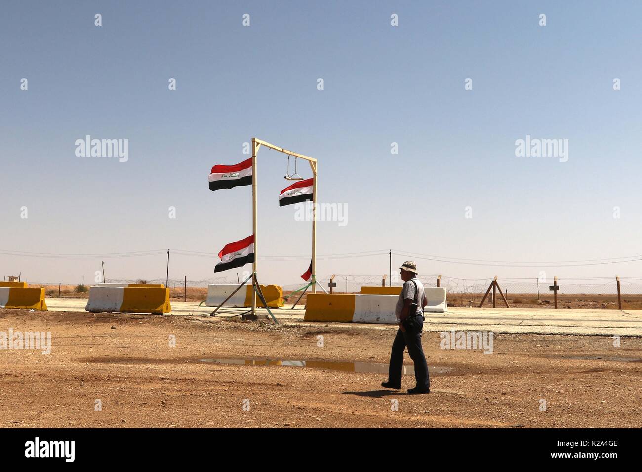 Amman. 30th Aug, 2017. A man walks on the Iraqi side of the border ...