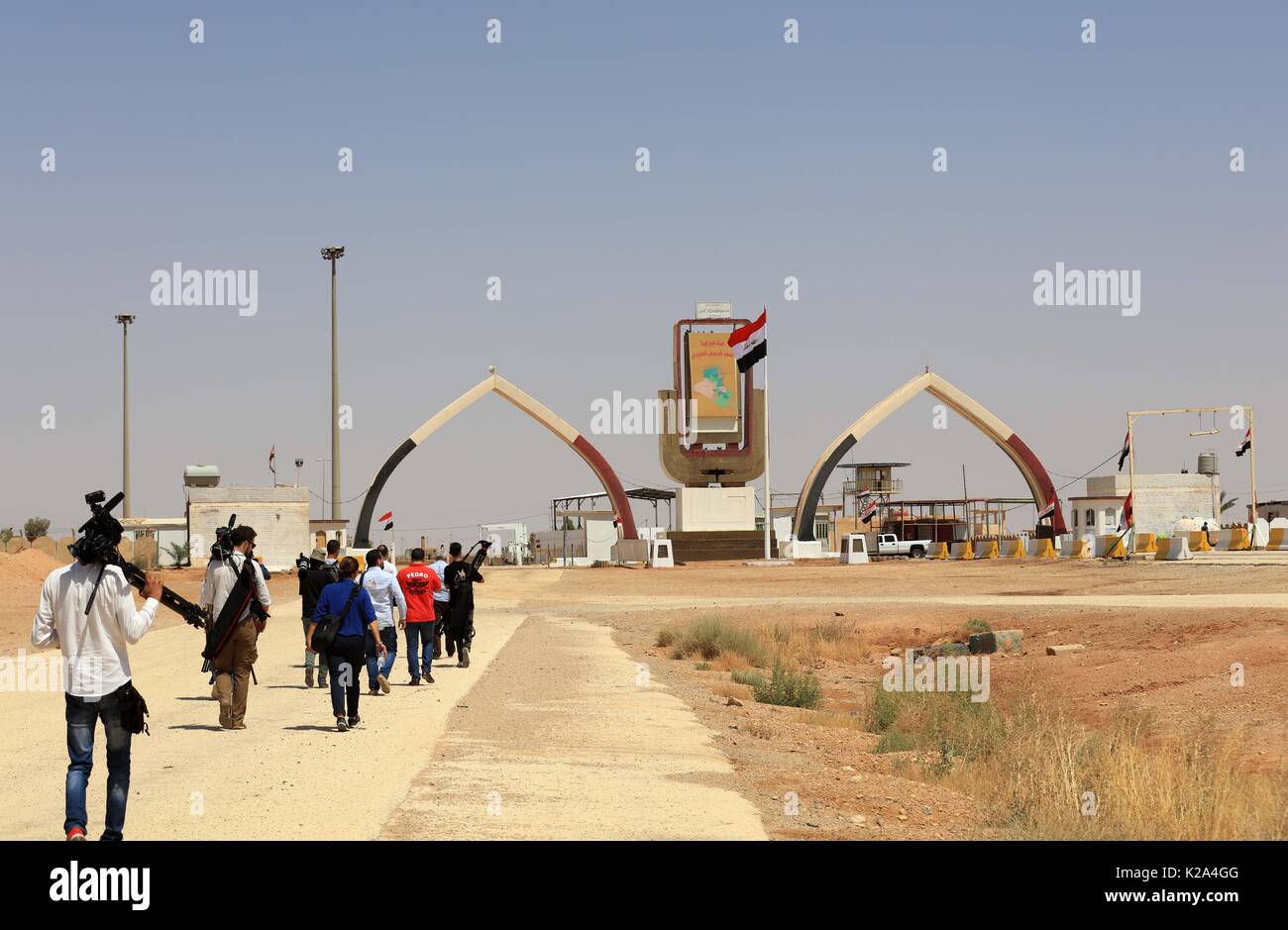 Amman. 30th Aug, 2017. People walk on the Iraqi side of the border ...