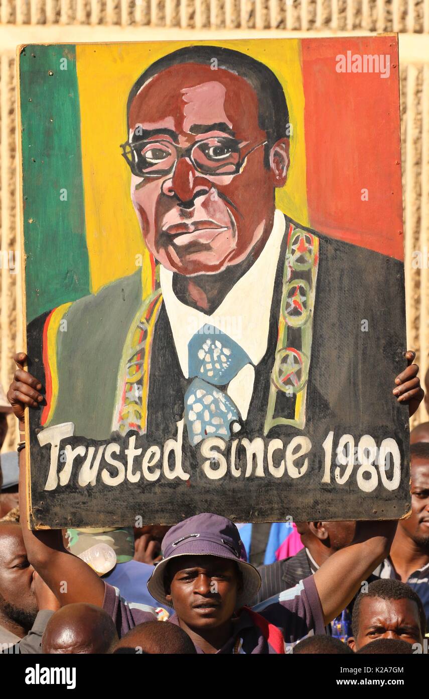 Harare. 30th Aug, 2017. A man holds Zimbabwean President Mugabe's ...