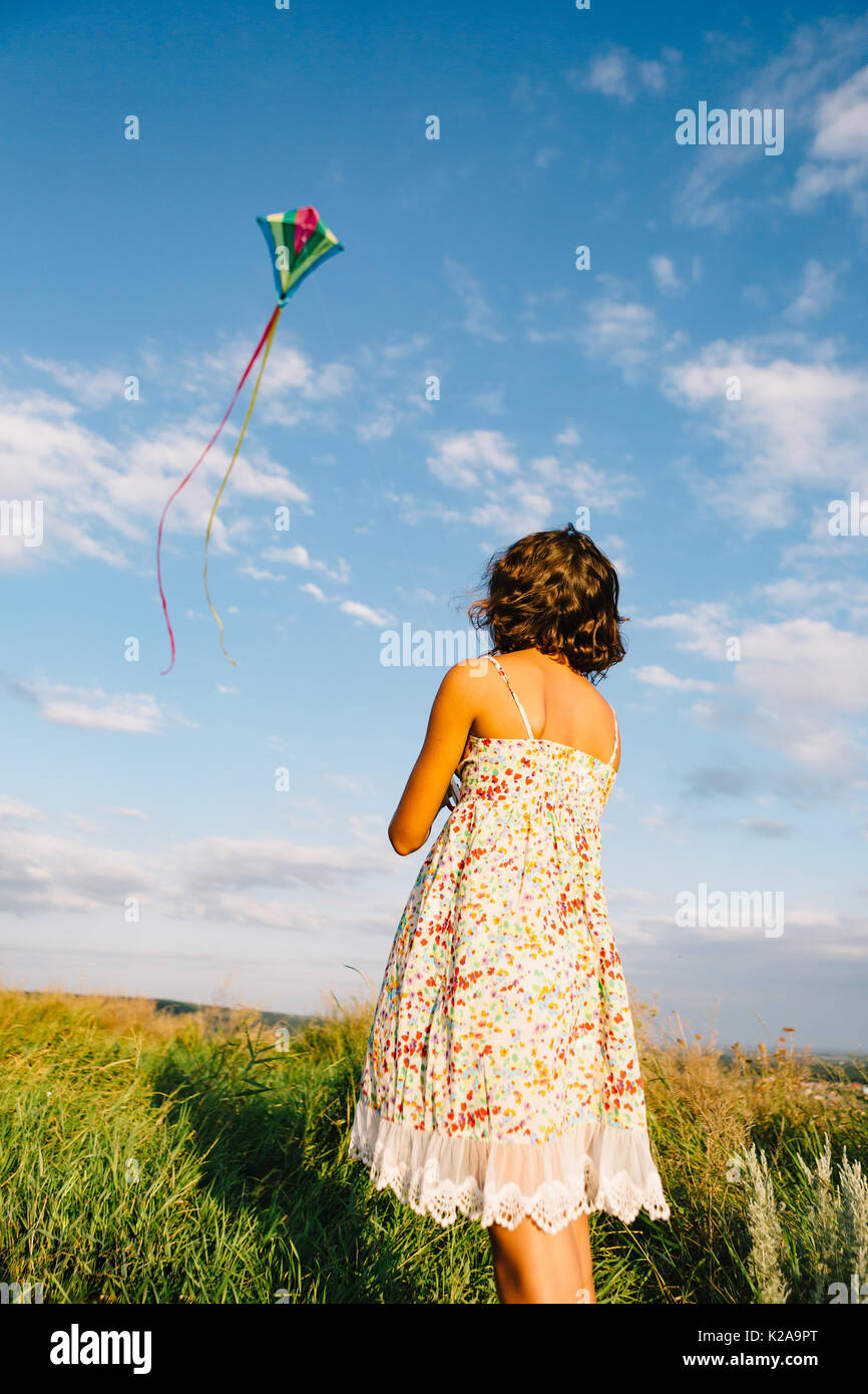 Girl playing with kite in field Stock Photo - Alamy