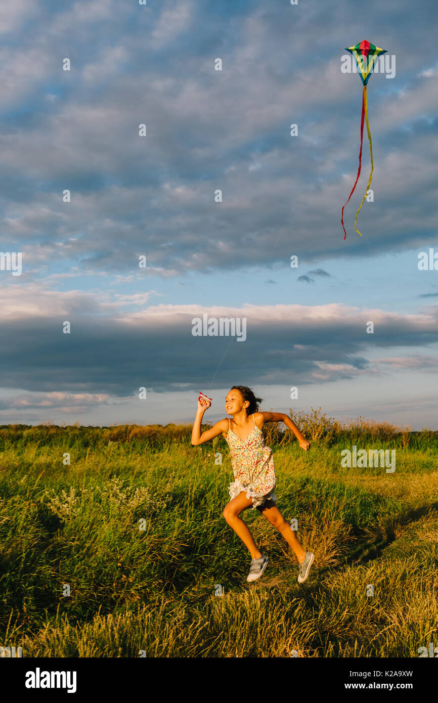 Cheerful girl running with kite Stock Photo - Alamy