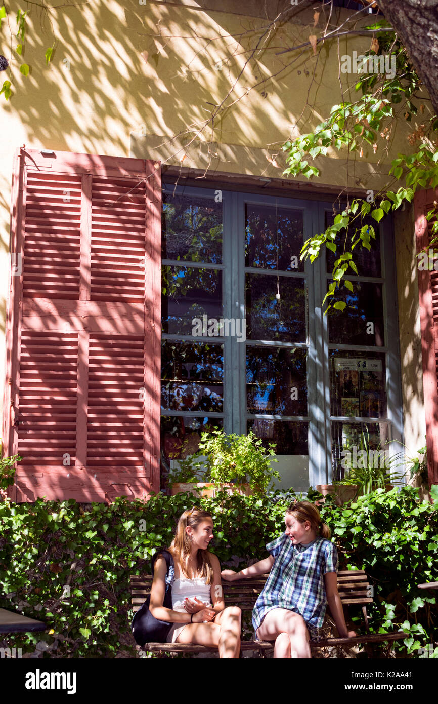 Two girls talking on bench hi-res stock photography and images - Alamy