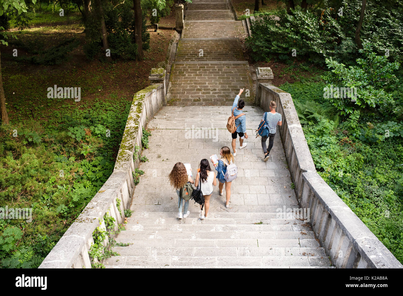 Teenage students walking on stone steps in front of university Stock ...