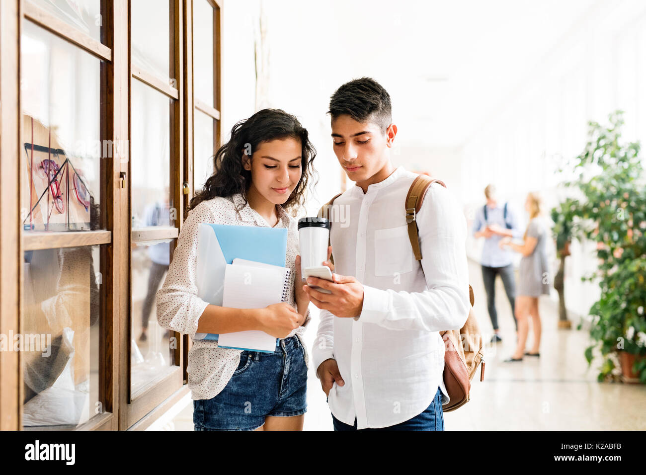 Attractive teenage student couple in high school hall Stock Photo - Alamy