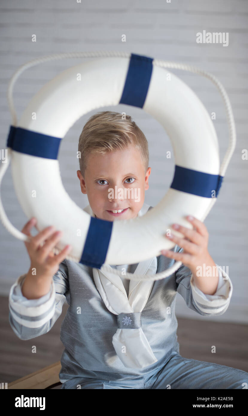 Cute sailor boy holding a life preserver in studio Stock Photo - Alamy