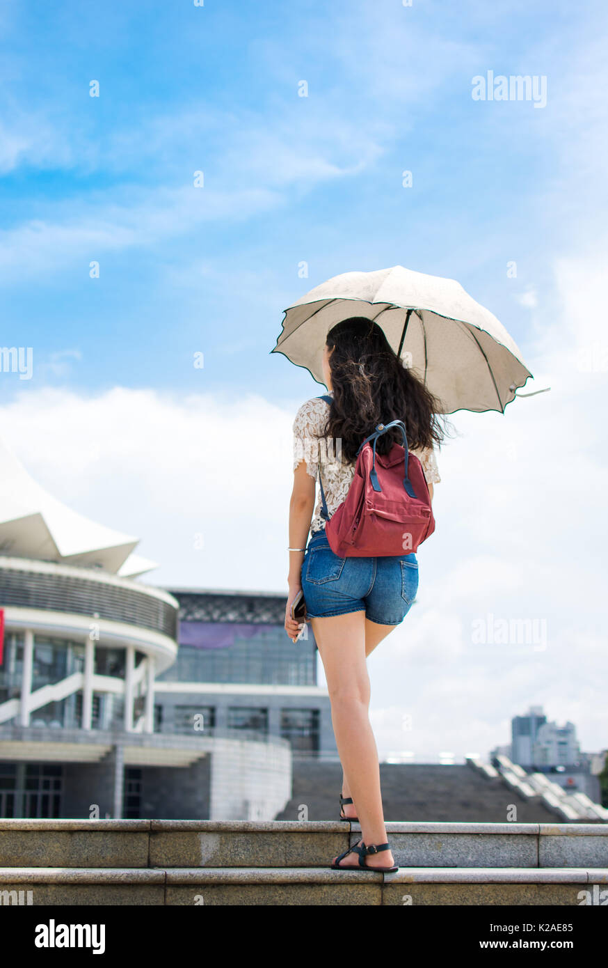 Woman walking up stairs with umbrella to protect from the sun Stock ...