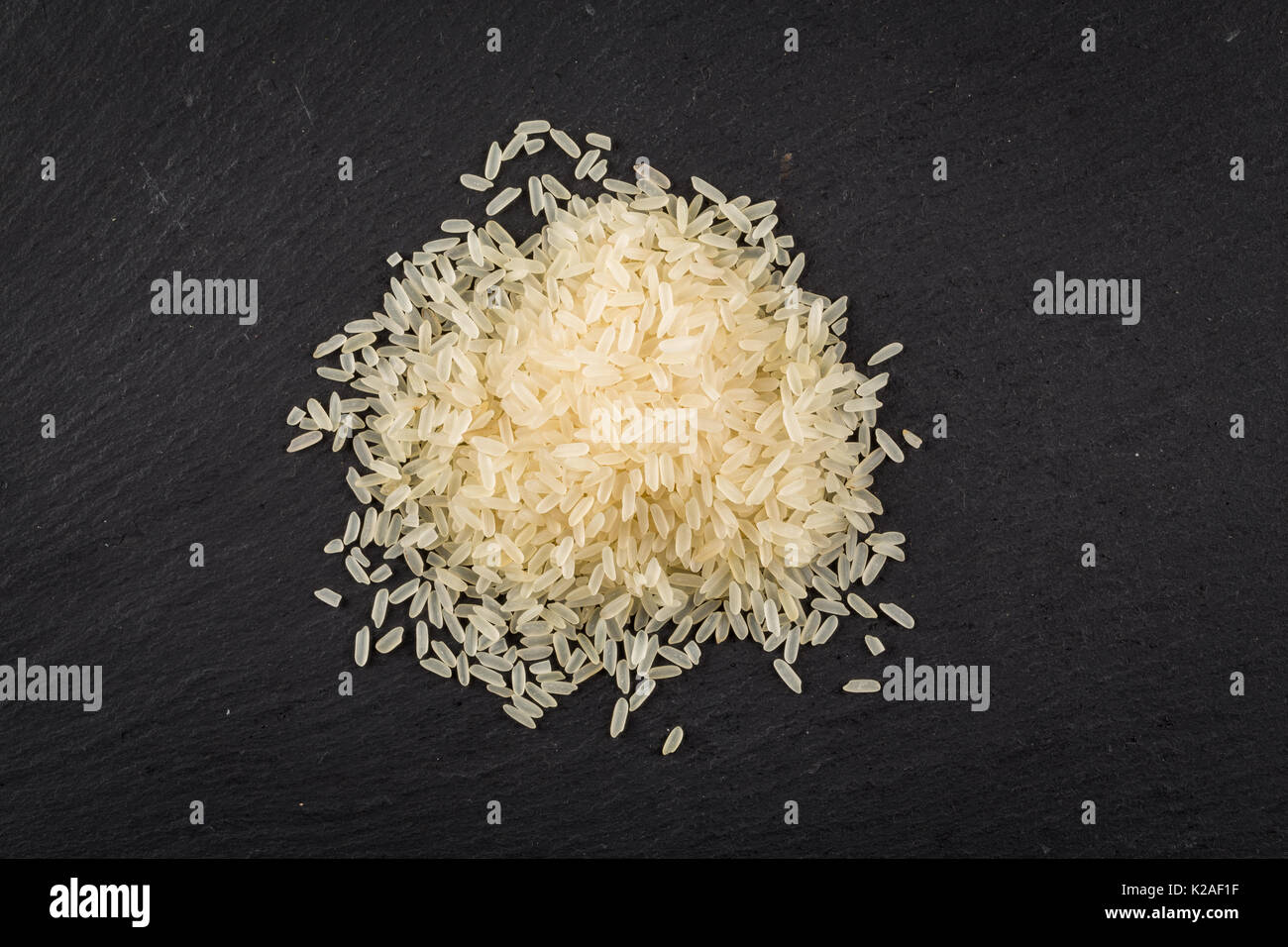 Rice heap close up on a dark background Stock Photo - Alamy