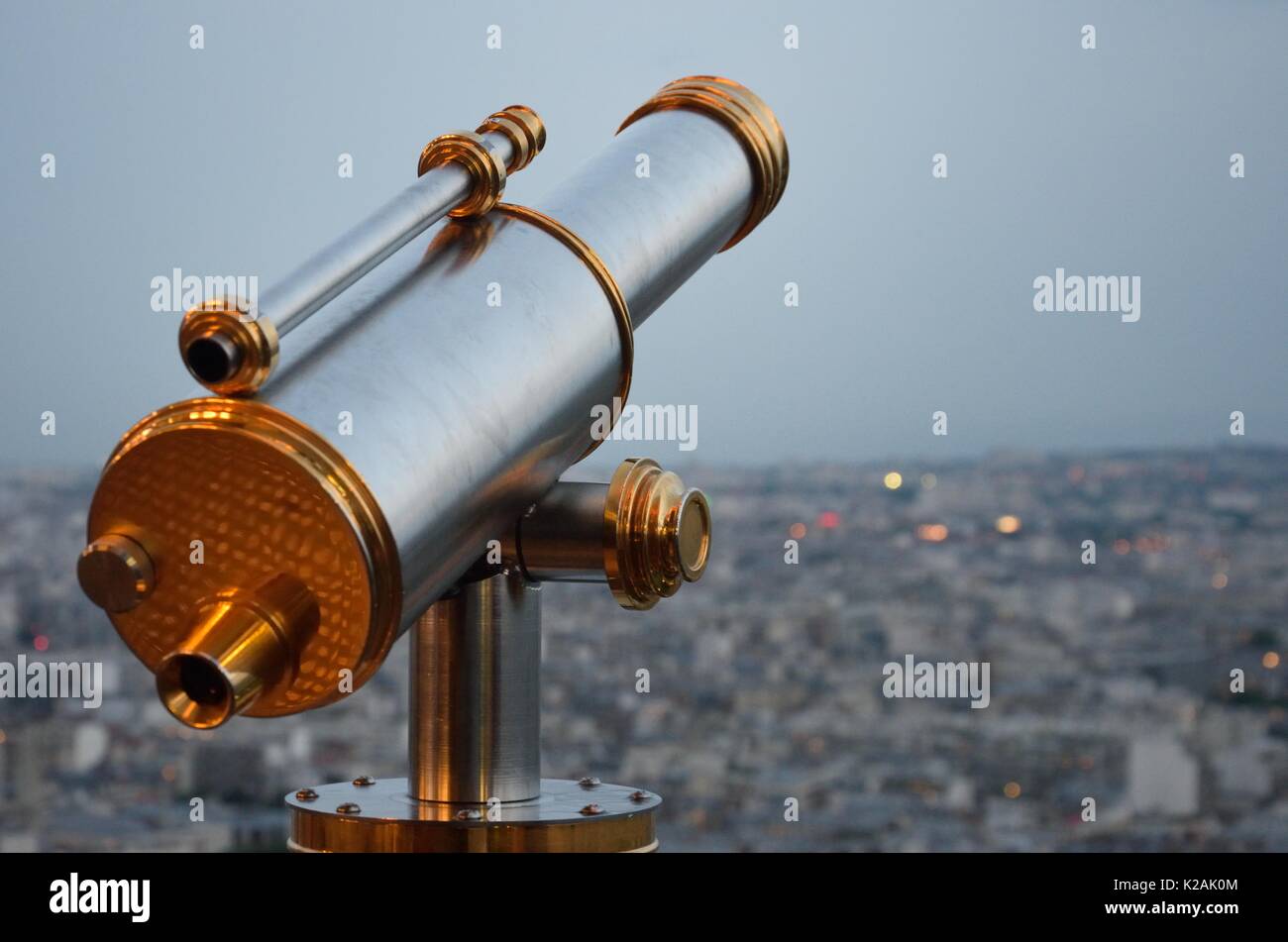 Vintage Telescope looking over city at dusk Stock Photo - Alamy