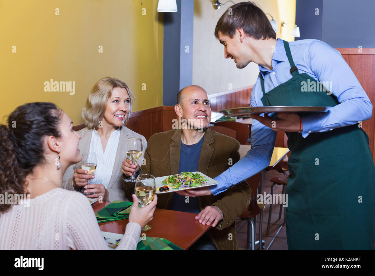 Waiter taking order at table of people having dinner together Stock ...