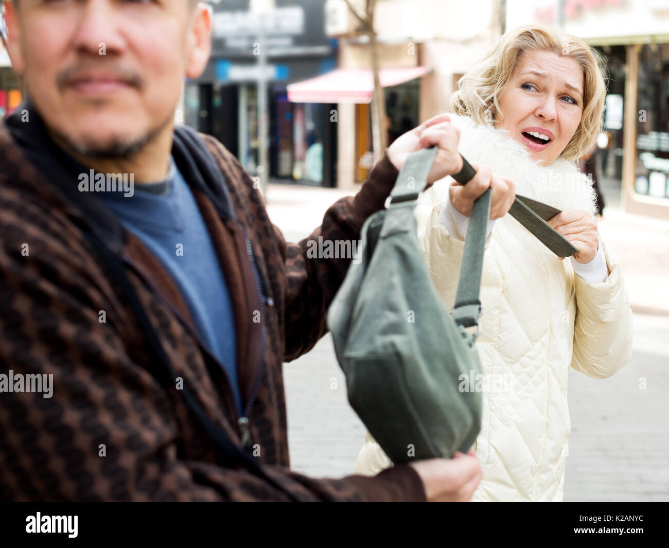 Senior man pulling female bag, outdoors robbery at day time Stock Photo ...