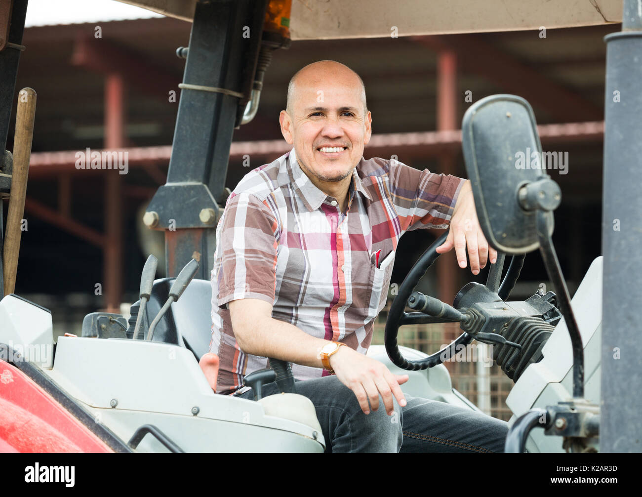 male driver operating modern tractor in livestock farm Stock Photo - Alamy
