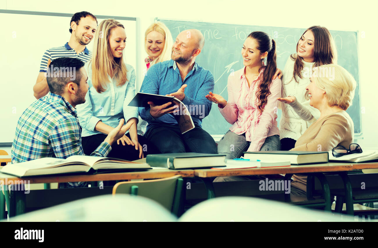 Teacher is laughing with his students in classroom during a break ...
