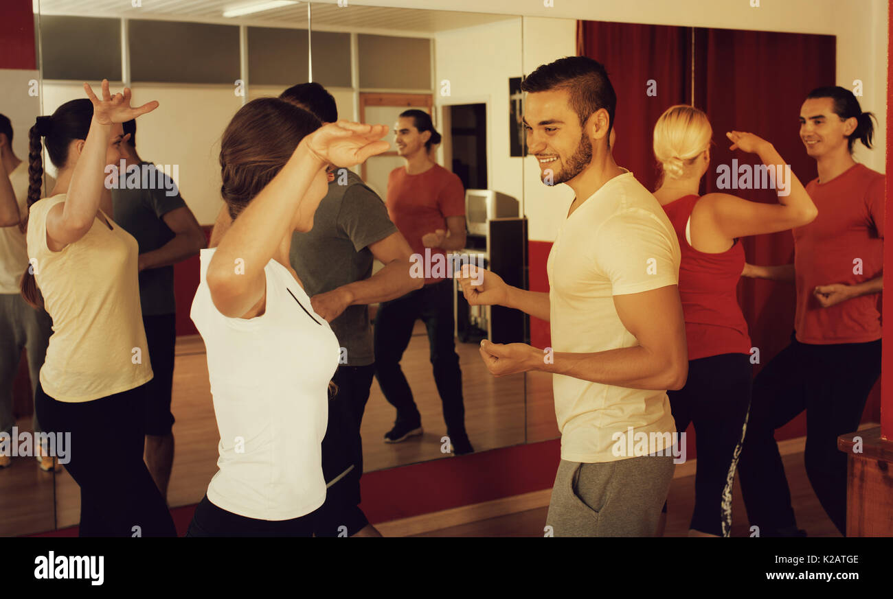 Happy men and women enjoying active dance in a dance studio Stock Photo ...