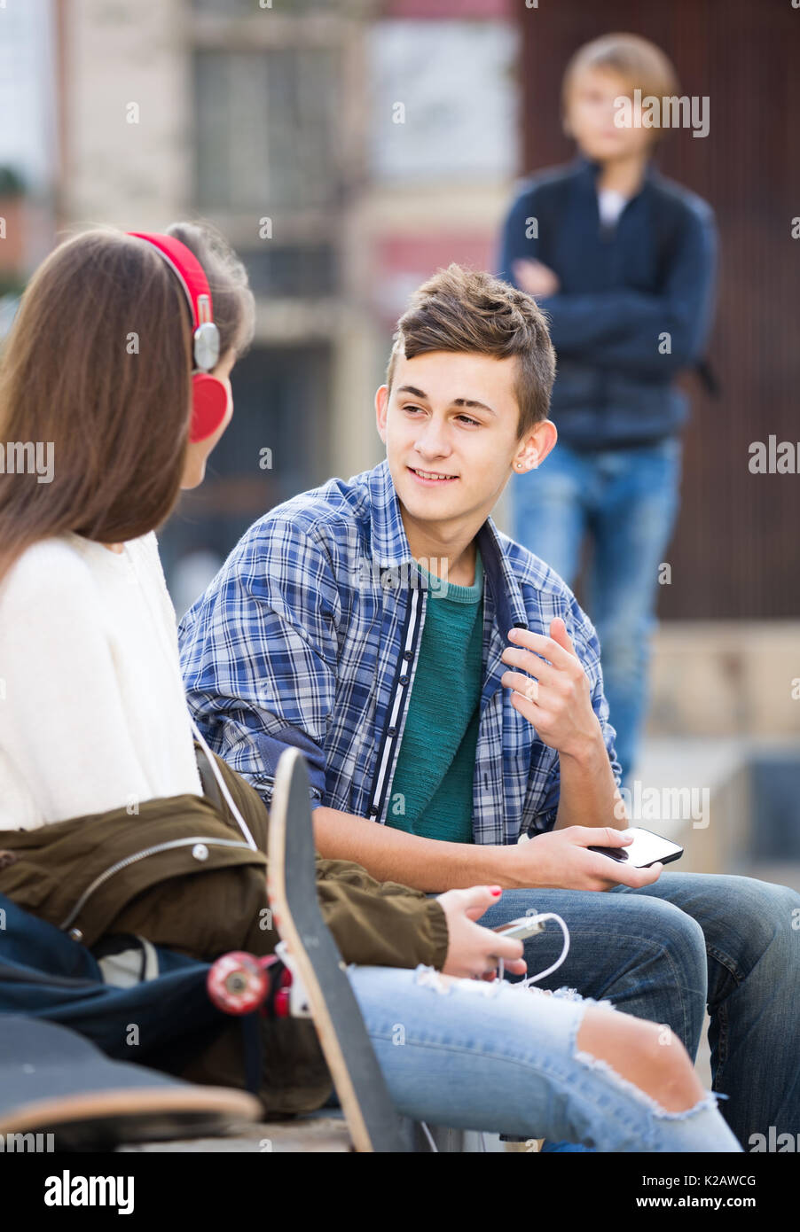 Jealous teen and his smiling russian friends after conflict outdoors ...