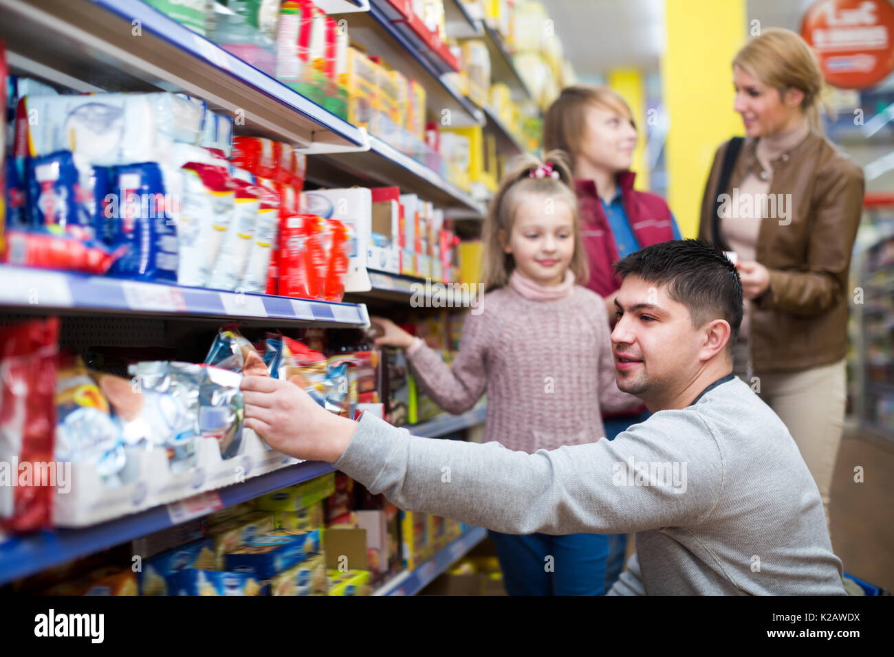 Middle-class family of four purchasing food in shop Stock Photo - Alamy