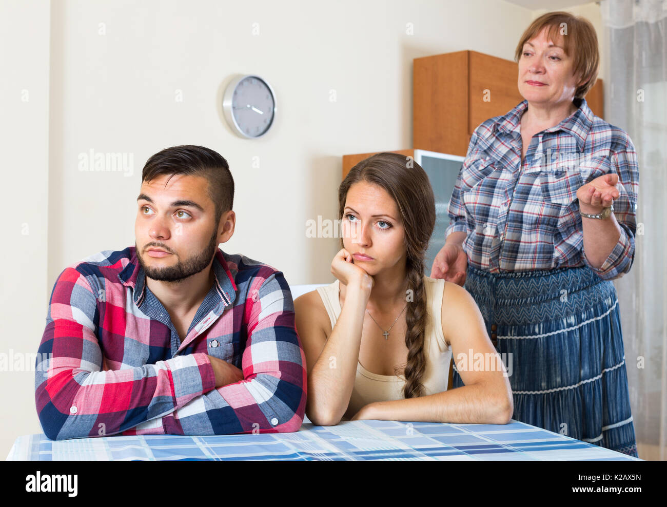 Home conflict between displeased young couple and elderly female ...