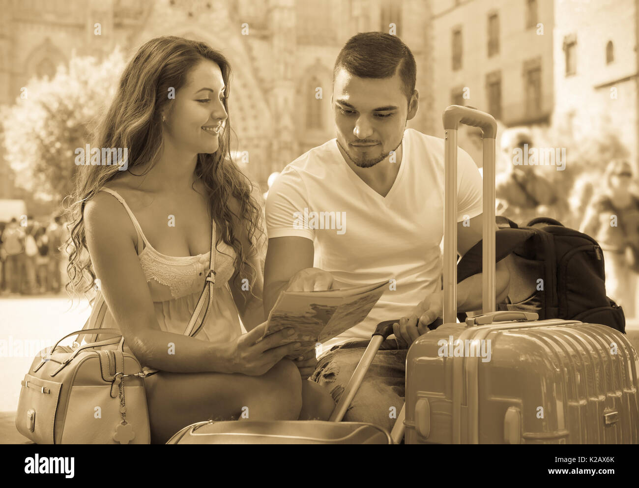 Man with girlfriend reading the map at street with luggage Stock Photo ...