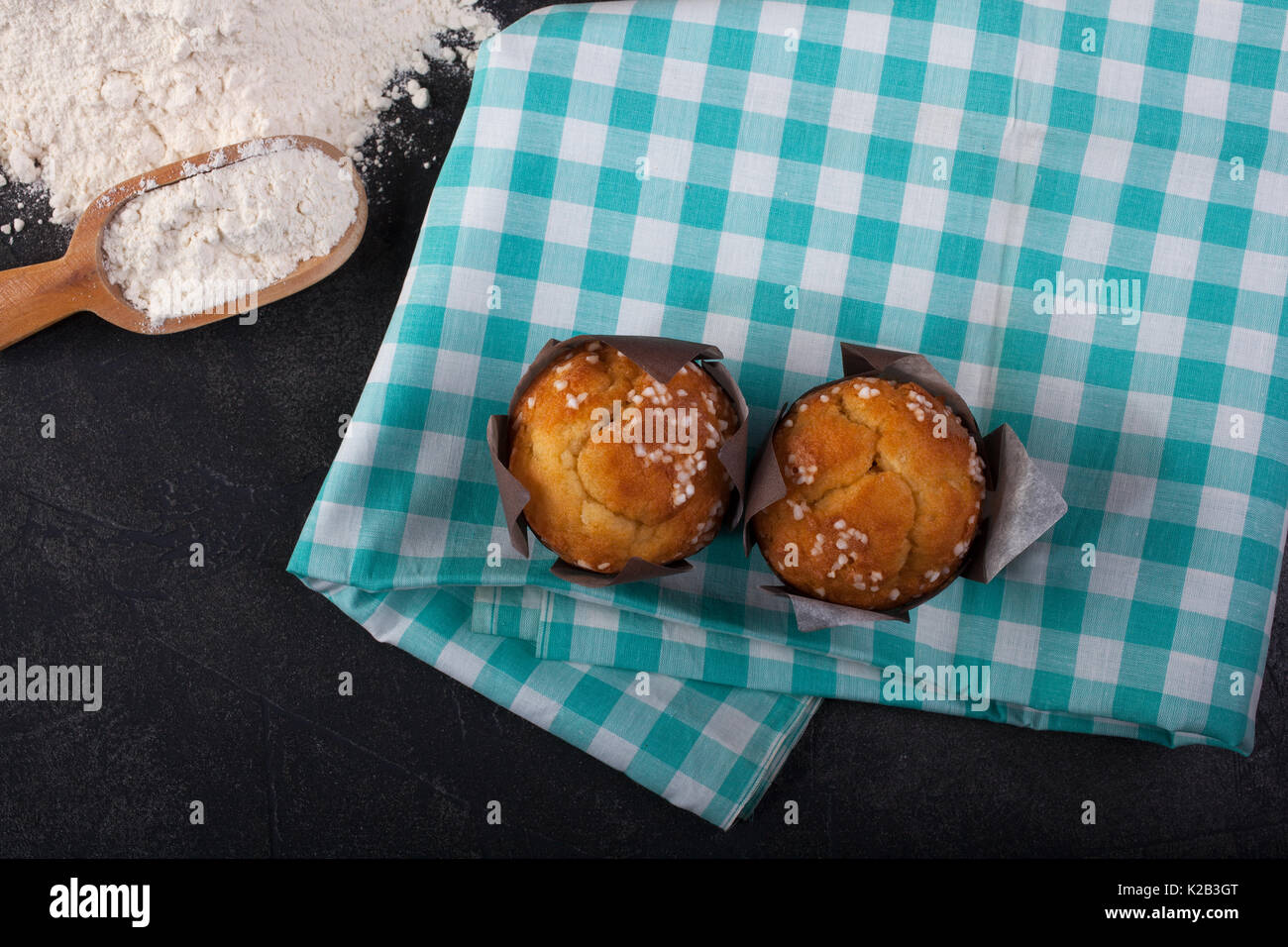 Two muffin on baby blue and white chequered dishcloth Stock Photo - Alamy