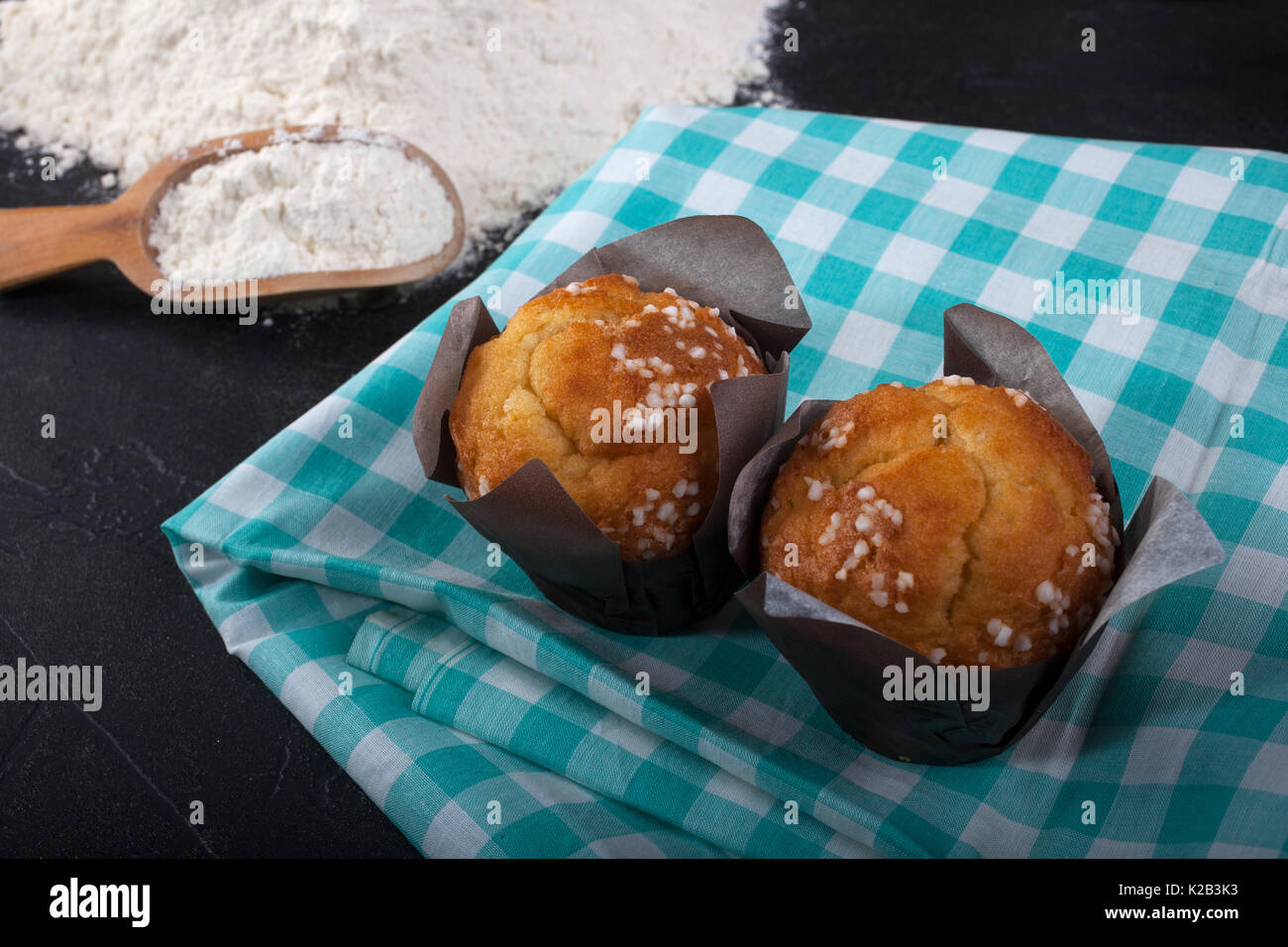 Two muffin on baby blue and white chequered dishcloth Stock Photo - Alamy