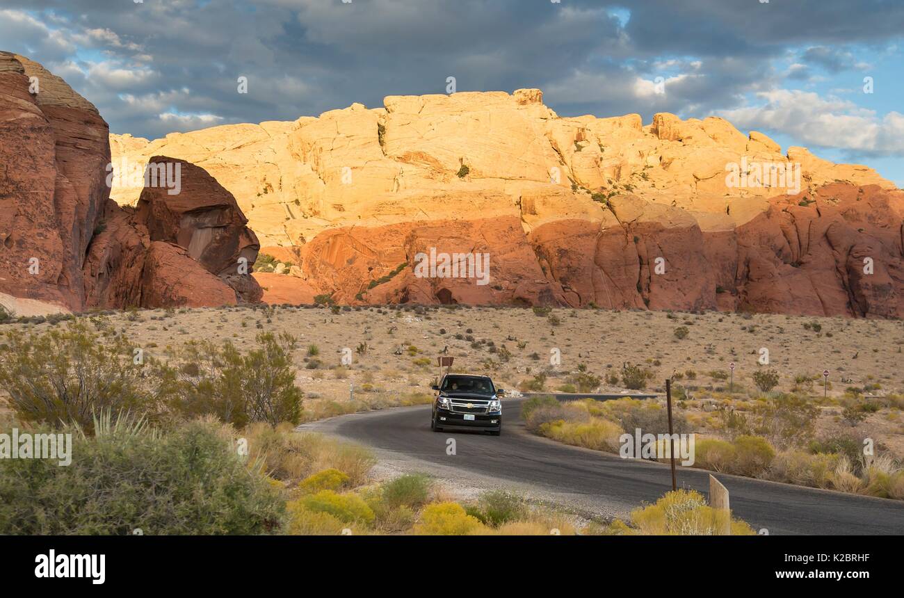 A car drives down a road through the red rock formations at the Red ...