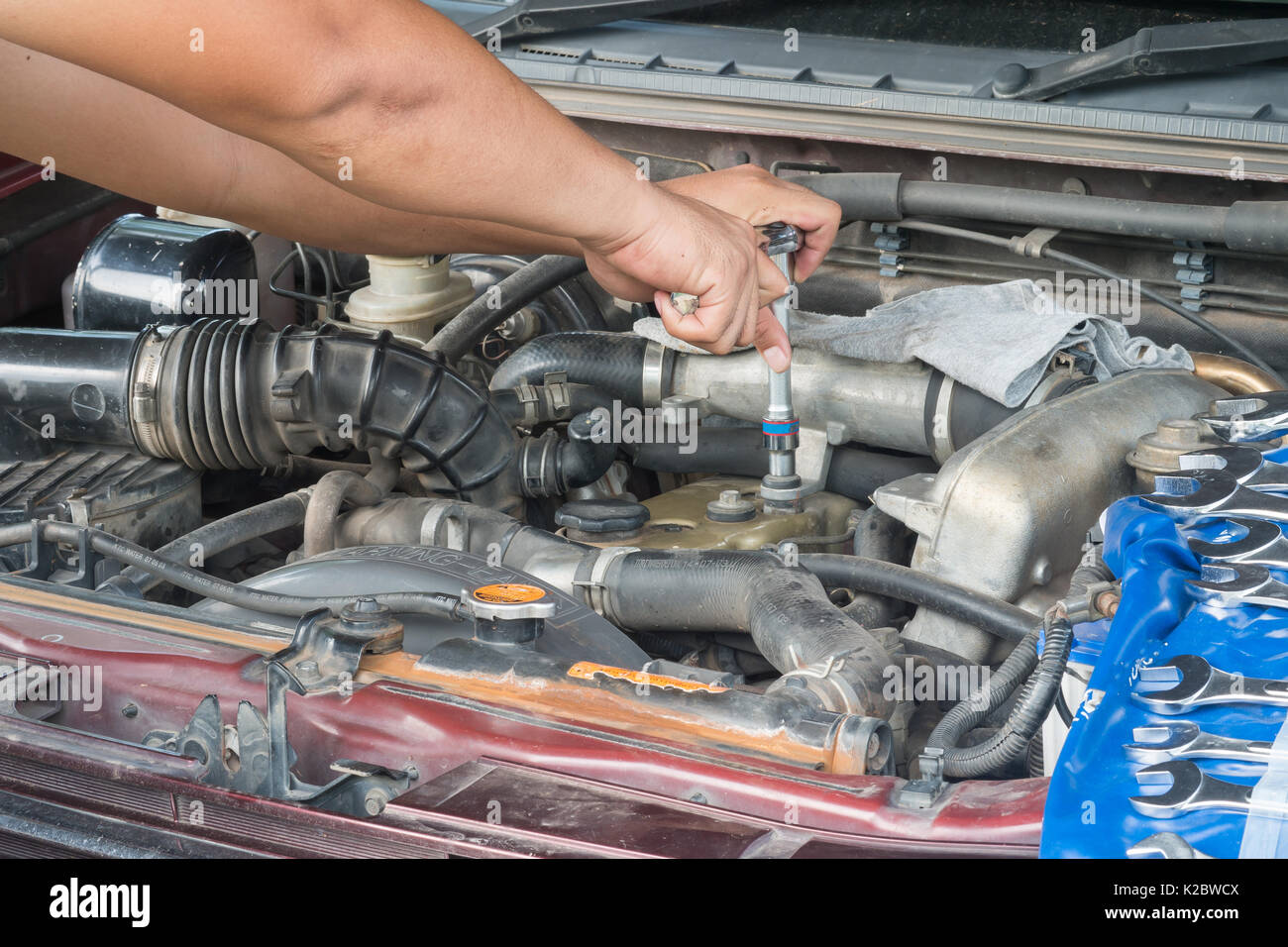 Hands repairing a modern car engine with a wrench Stock Photo - Alamy