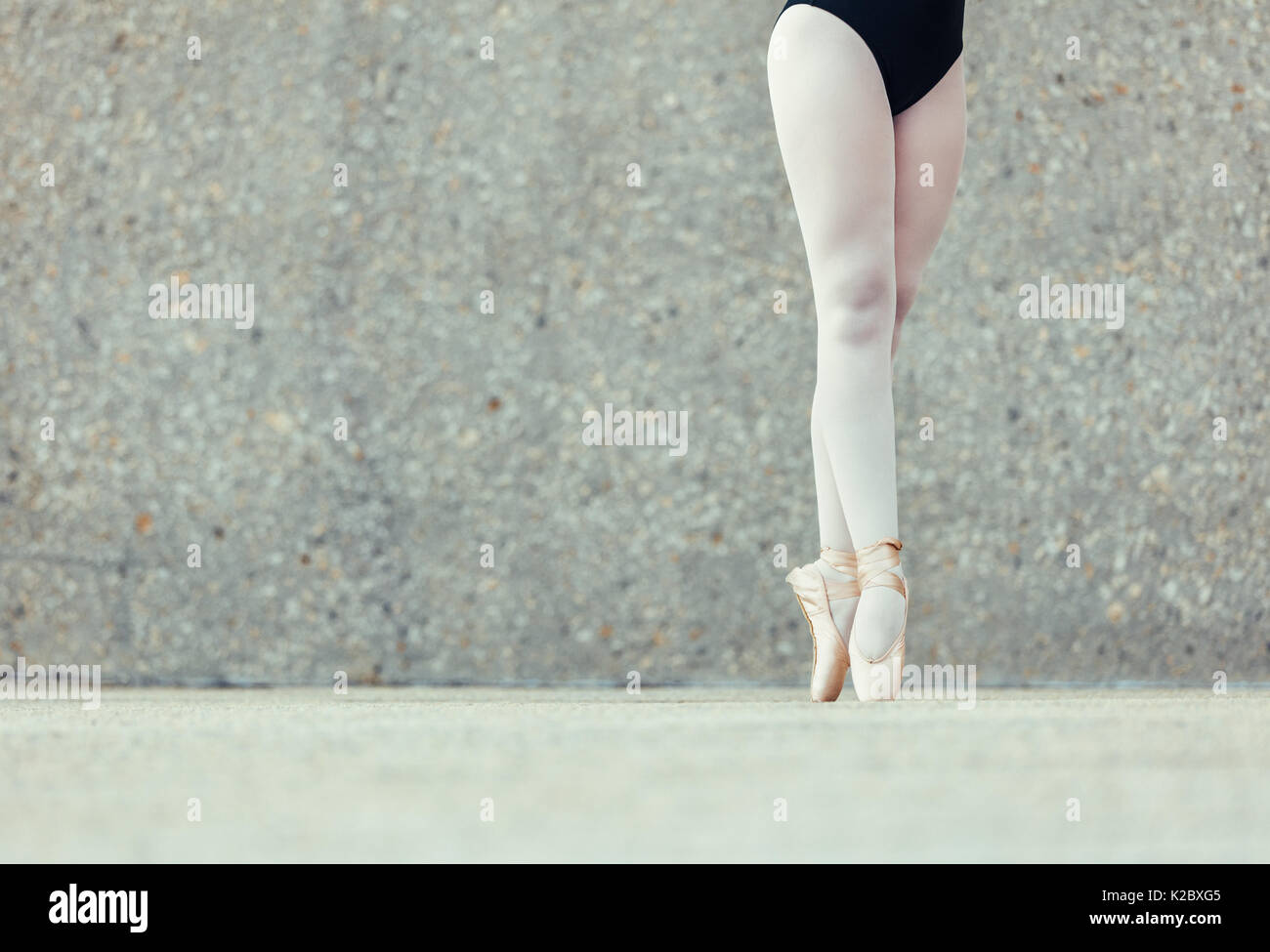 Closeup shot of legs of a female ballet dancer standing on her toes ...